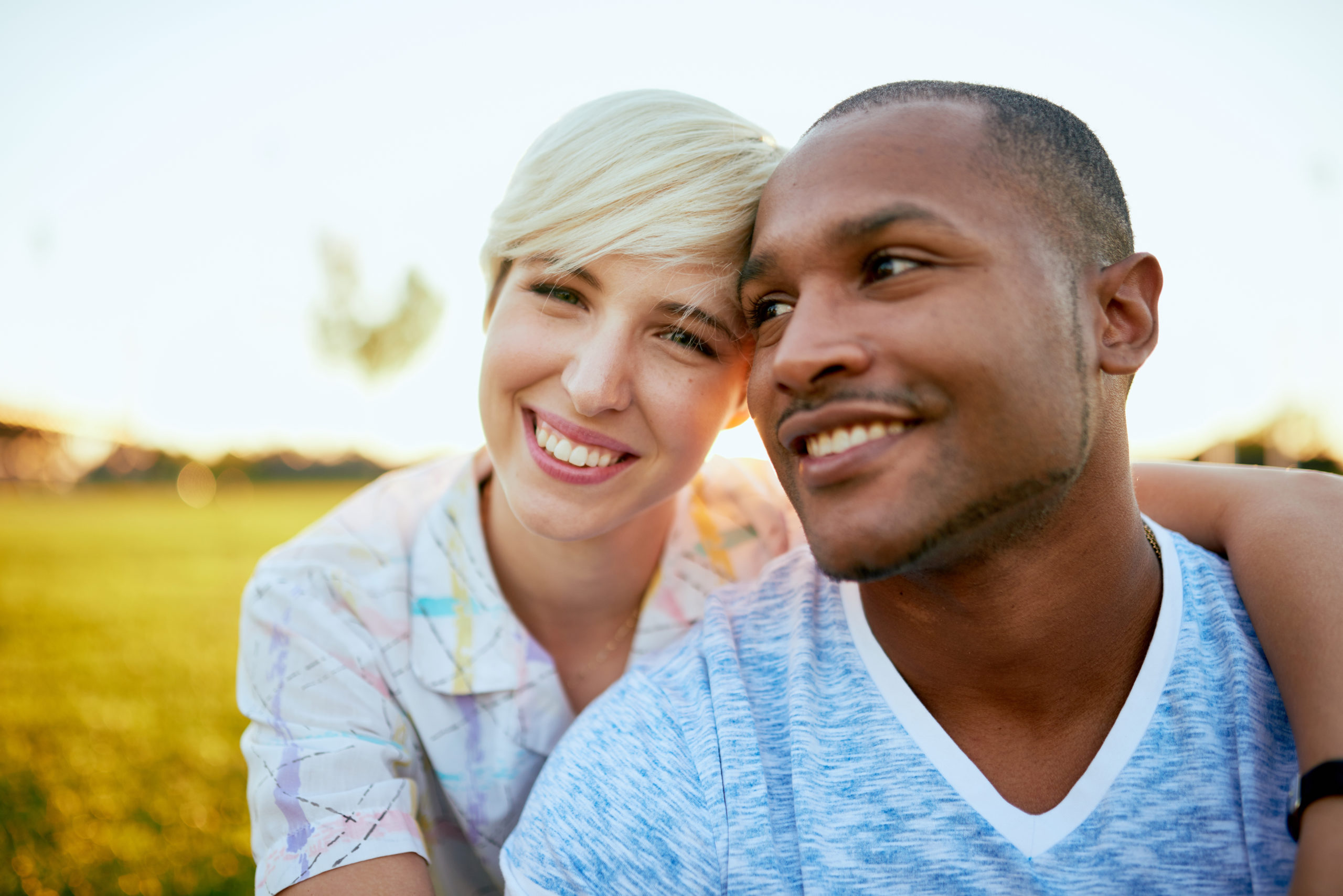 Mixed Race Couple Of Millennial In A Grass Field Embracing For A Fun Tender Moment Mecklenburg